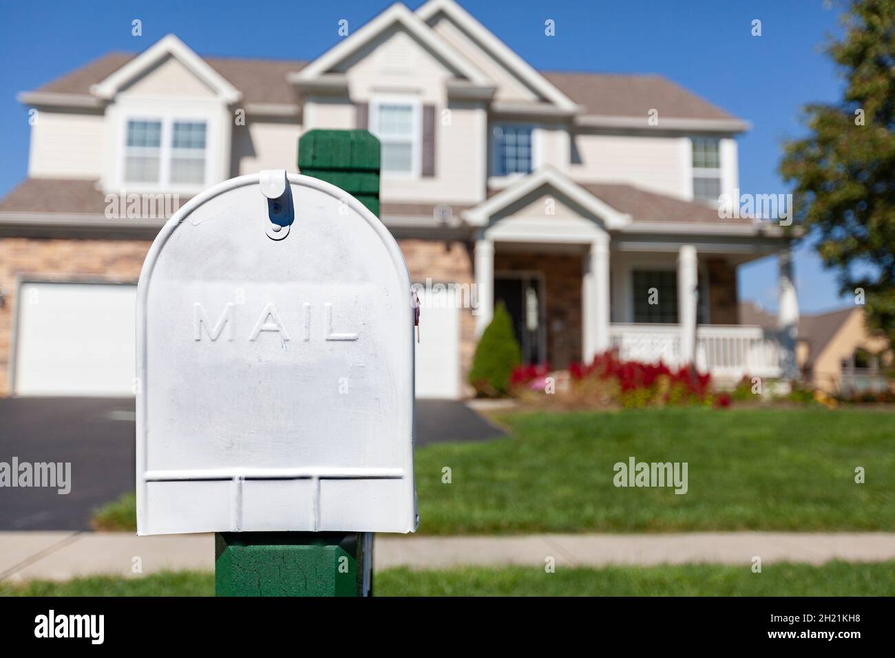 Close up isolated image of a white painted metal mail box in front of a ...
