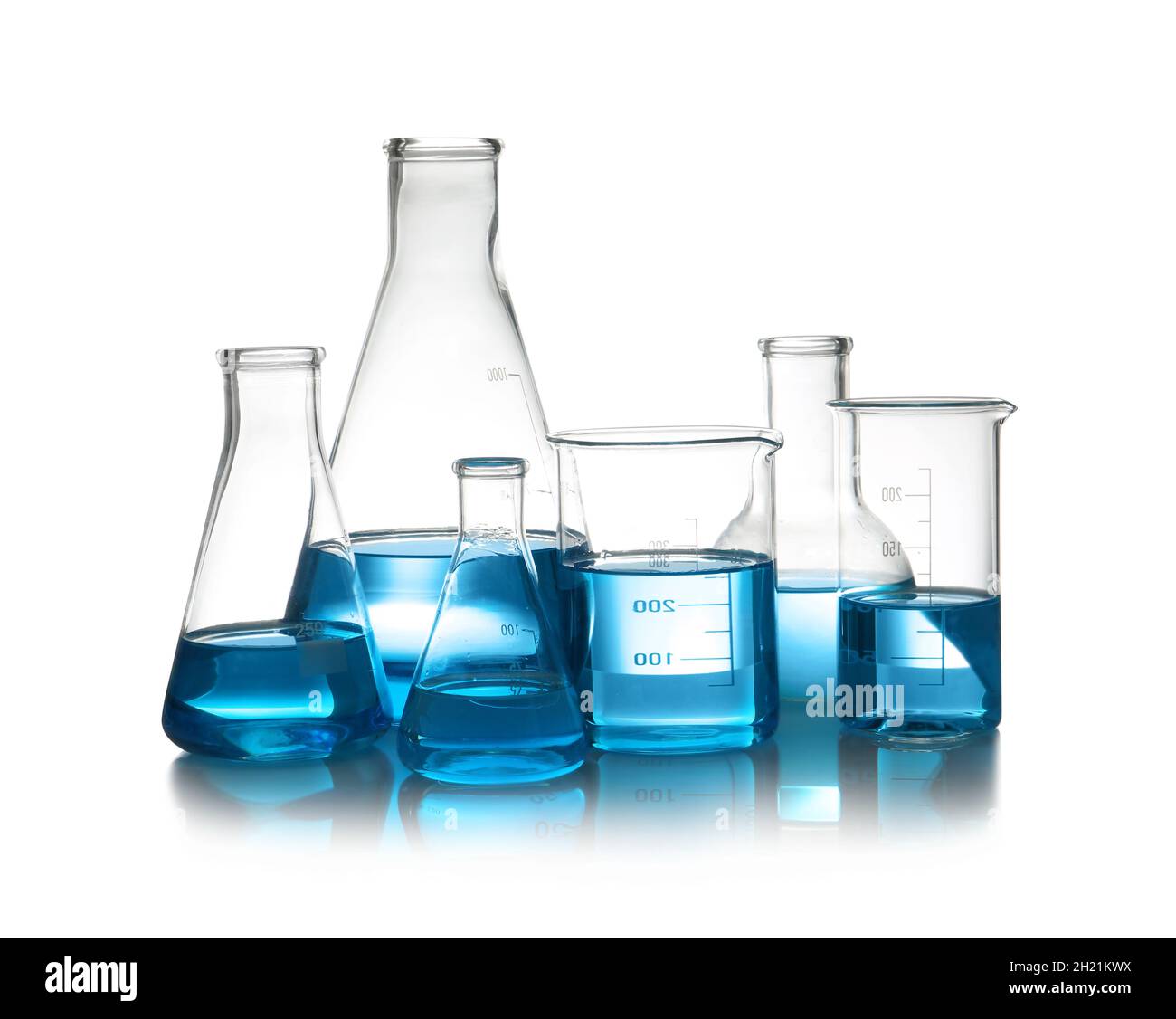 Laboratory glassware with liquid on table against white background ...