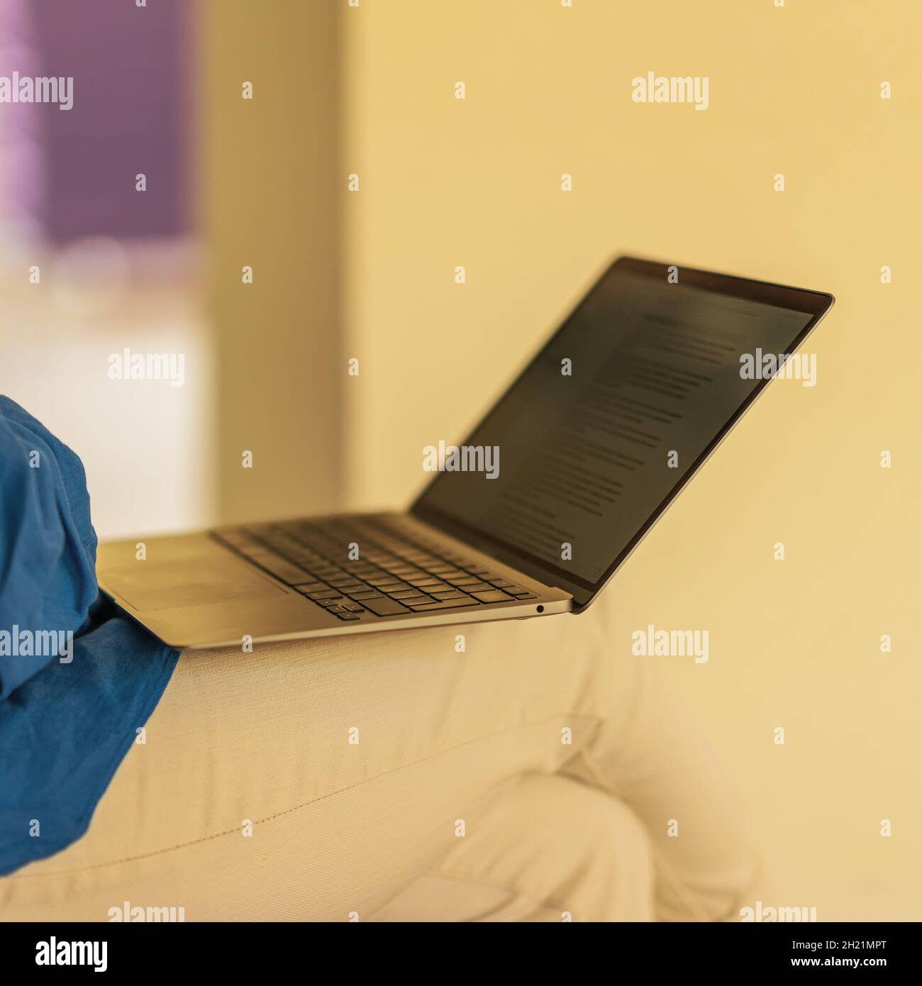 Open laptop on lap of abstract person behind scenes, soft selective ...