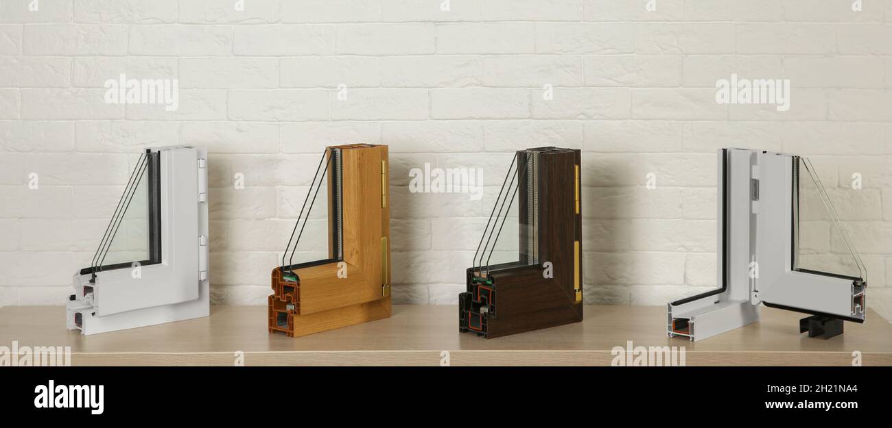 Samples of modern window profiles on table against brick wall ...
