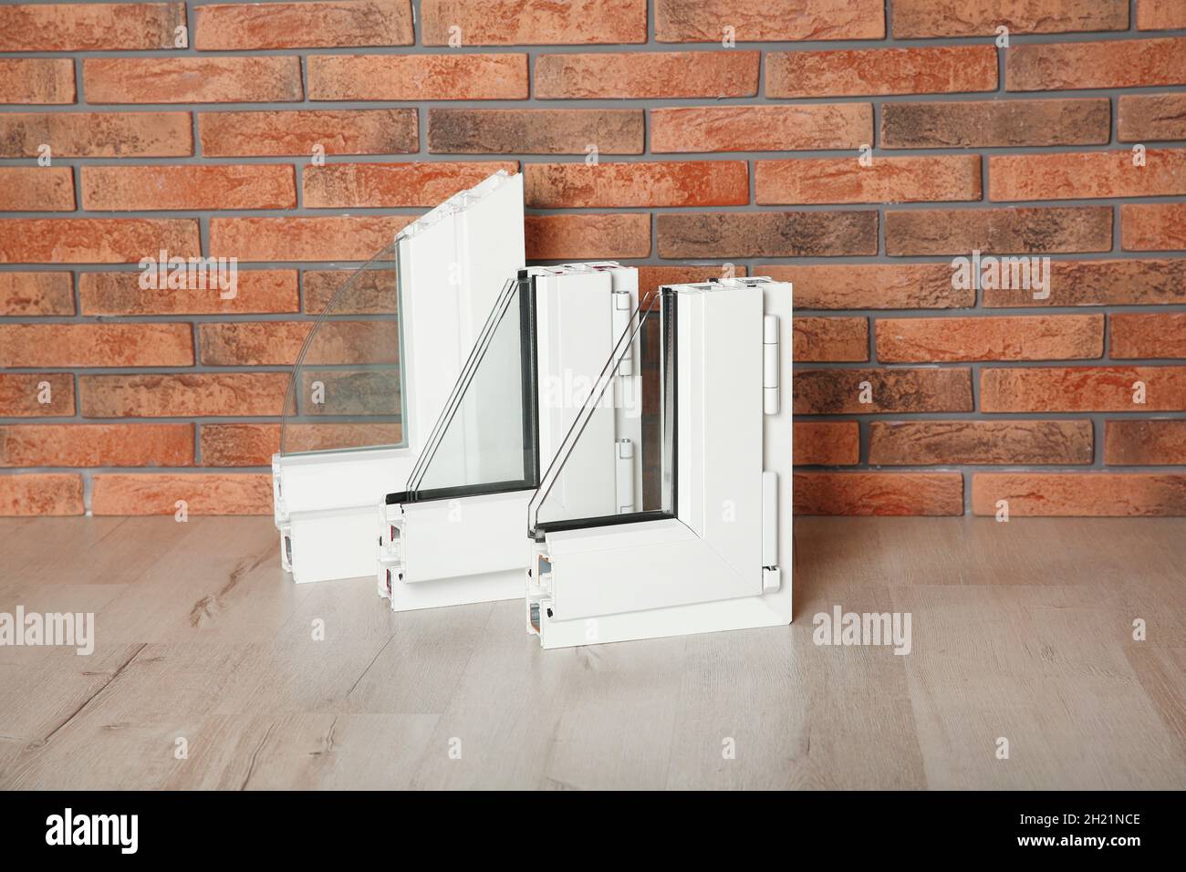 Samples of modern window profiles on floor against brick wall ...