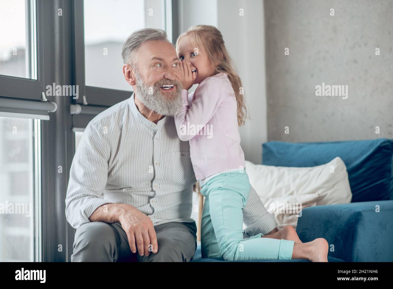 A cute blonde girl sharing secrets with her father Stock Photo - Alamy