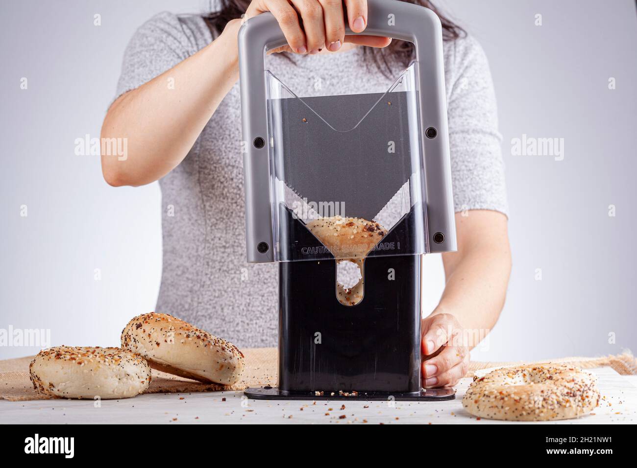 Cacuasian woman wearing short sleeve t shirt is slicing fresh baked ...