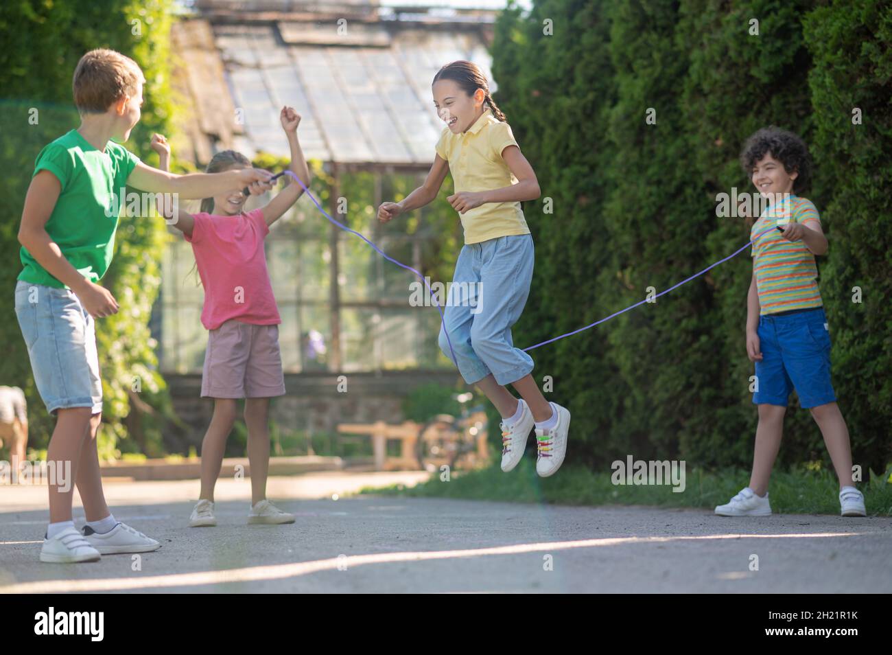Girl with pigtails jumping rope with friends Stock Photo - Alamy