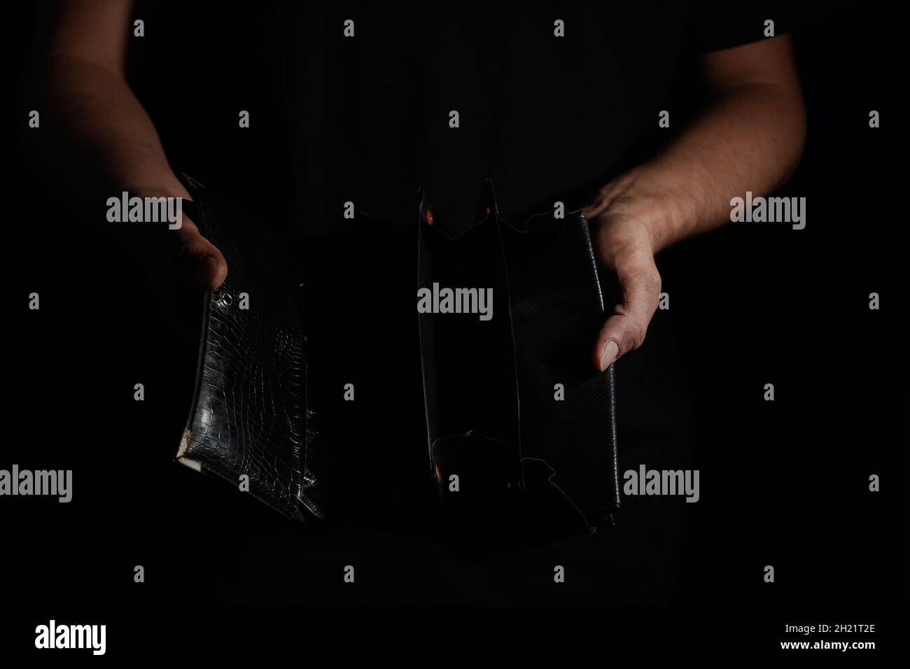 Poor man with empty wallet on dark background, closeup Stock Photo - Alamy