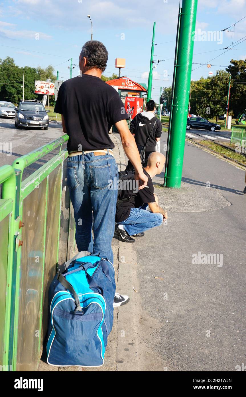 POZNAN, POLAND - Aug 29, 2013: A smoking man with large bag leaning ...