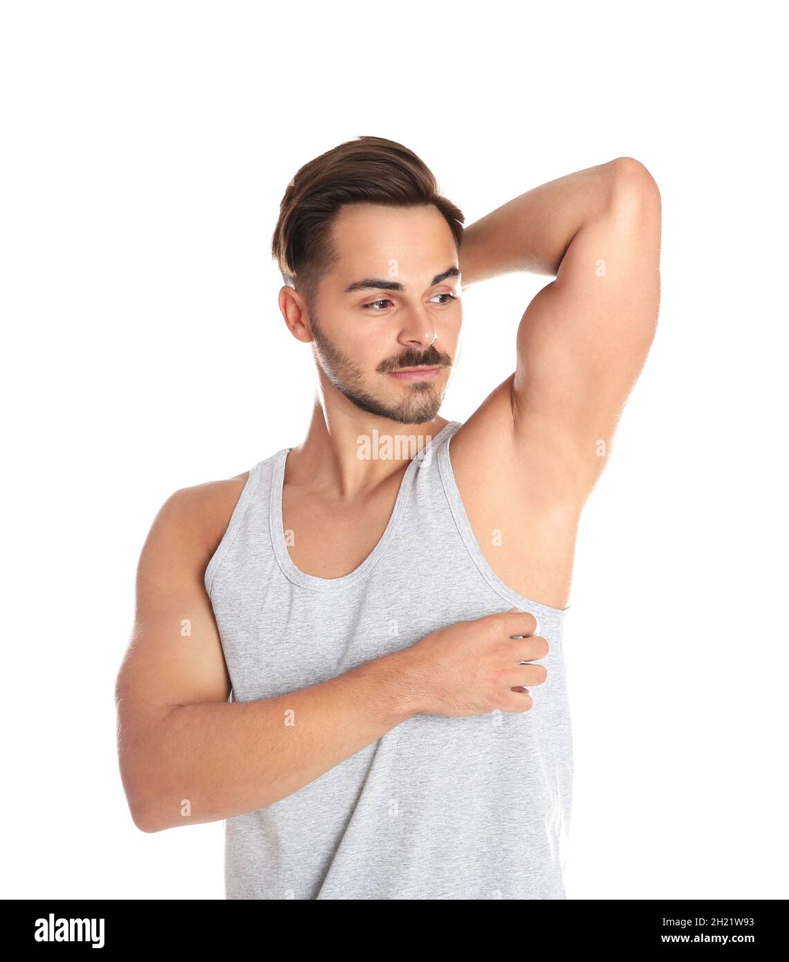 Handsome young man showing armpit on white background. Using deodorant ...