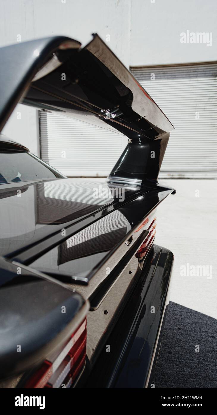 Vertical shot of a rear wing of a black car parked on a street Stock ...