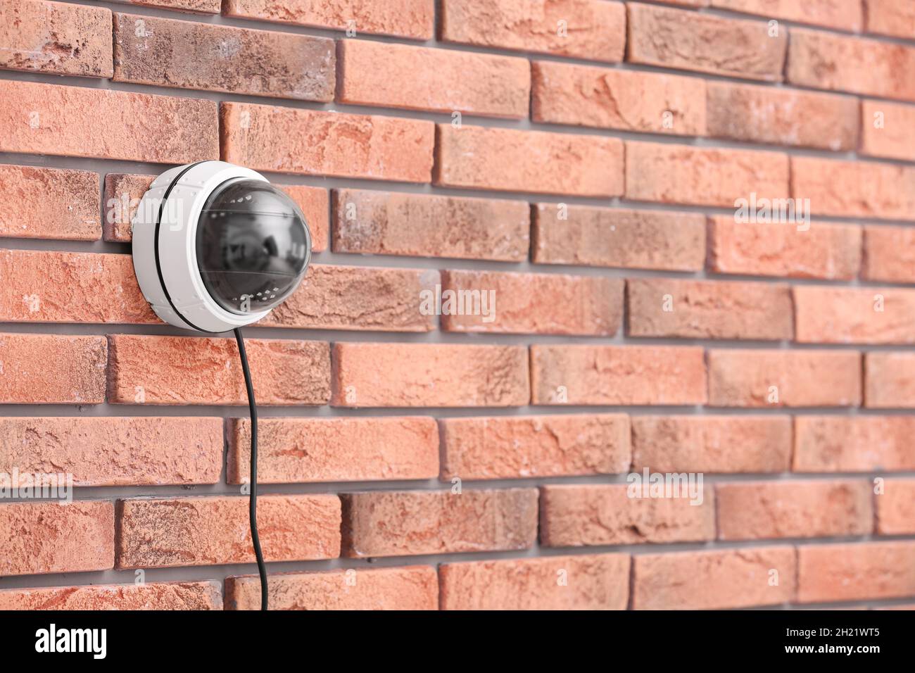 Modern security CCTV camera on brick wall Stock Photo - Alamy