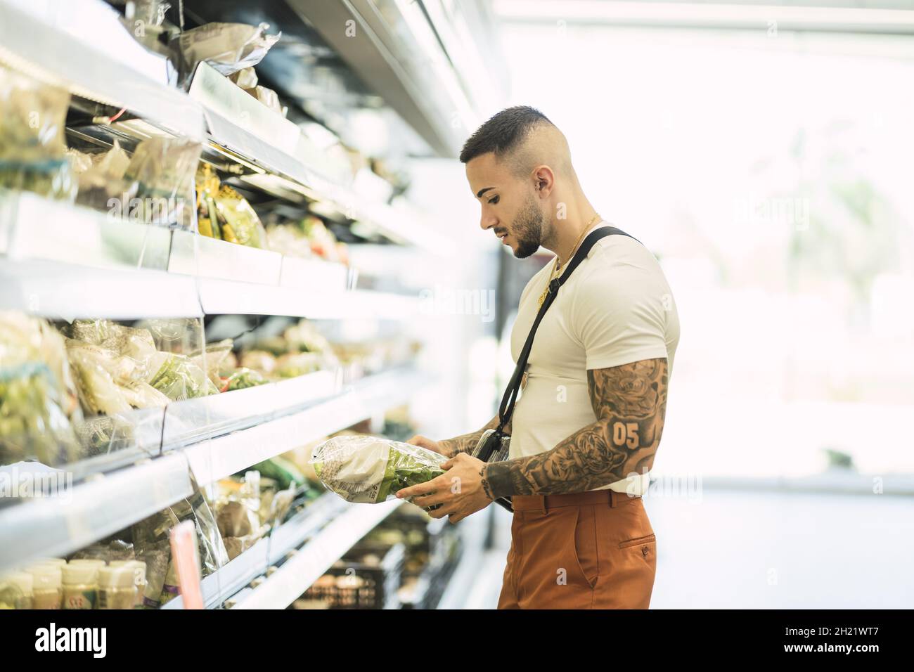 Horizontal side view of a guy shopping in the grocery store Stock Photo ...