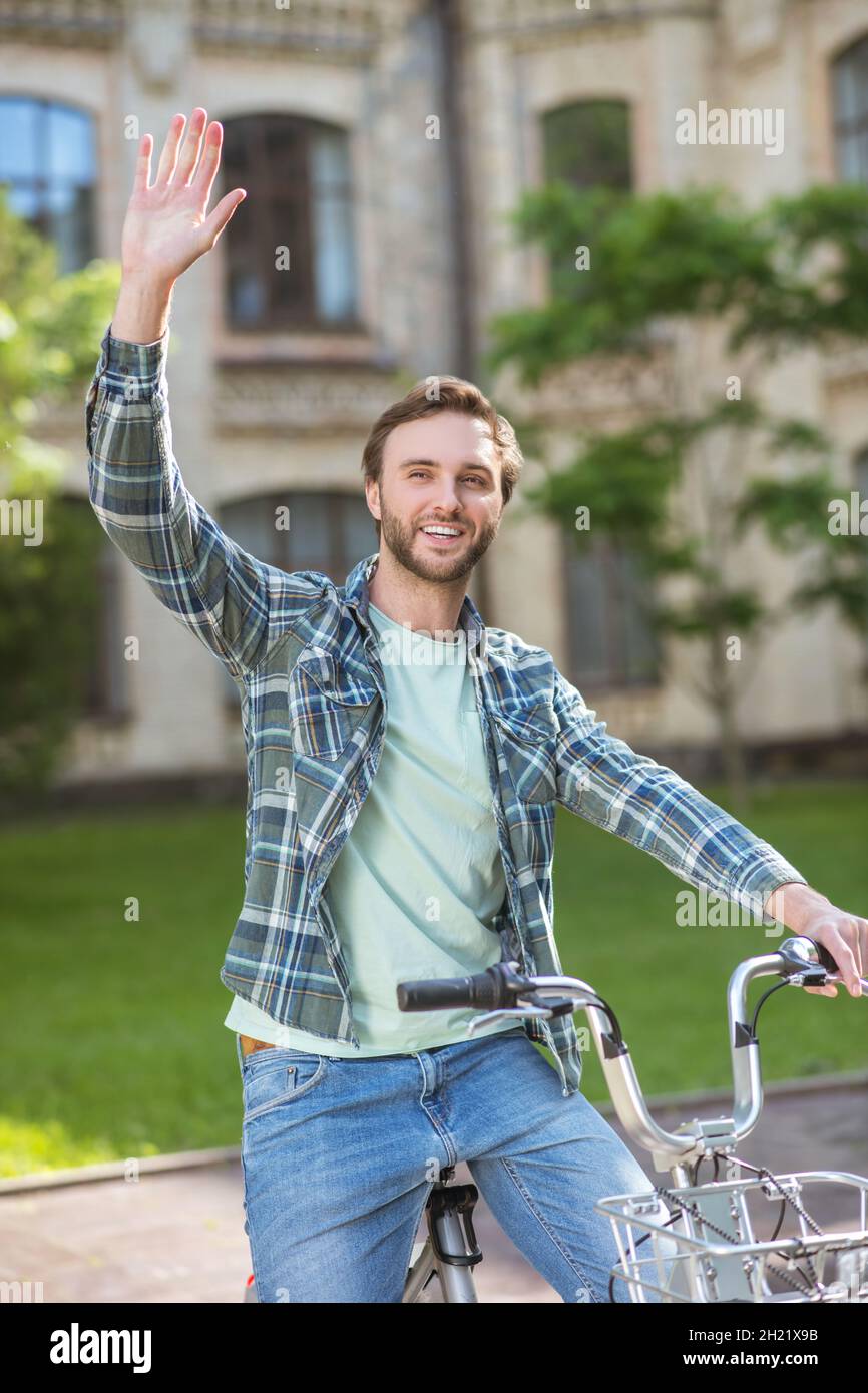A picture of a young man in aplaid shirt on a bike Stock Photo - Alamy