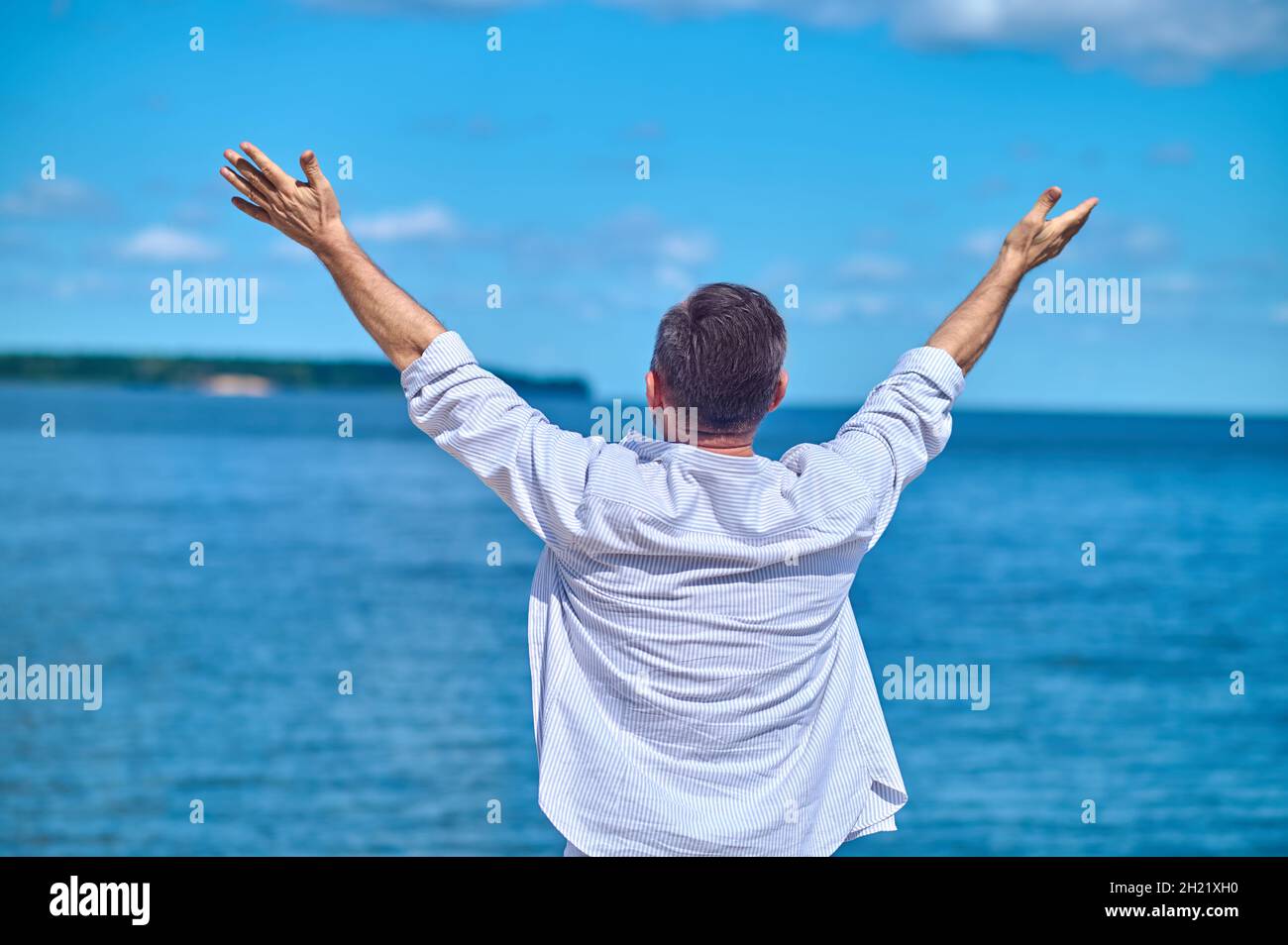 Man with raised hands with back to camera Stock Photo - Alamy