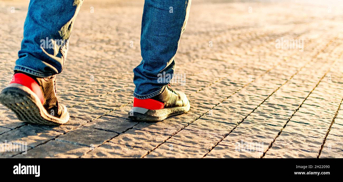 Closeup shot of a male wearing sneakers walking on the street Stock ...