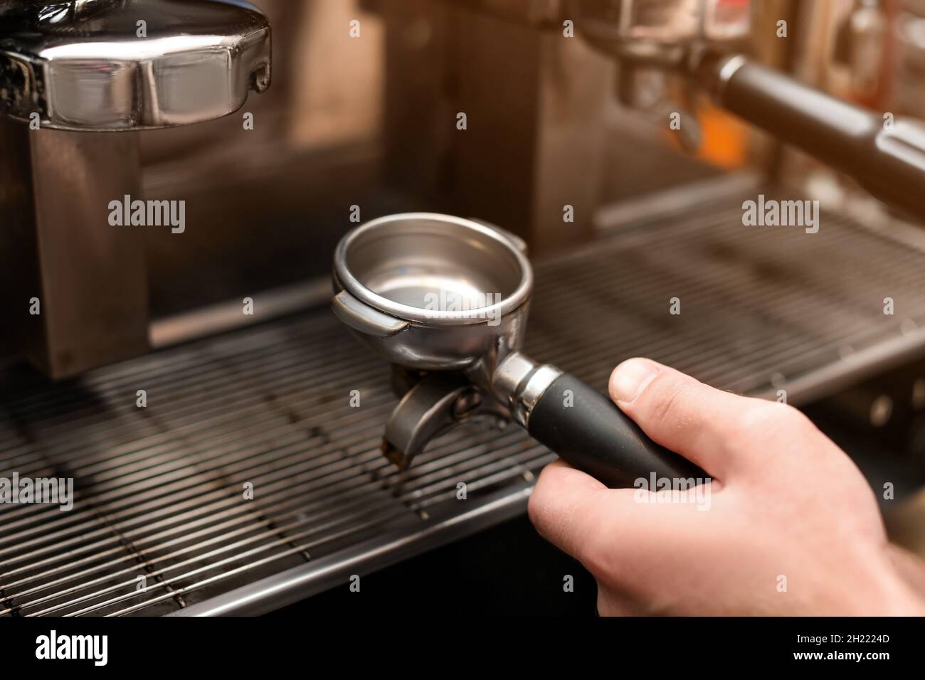 Male barista making espresso using professional coffee machine, closeup ...