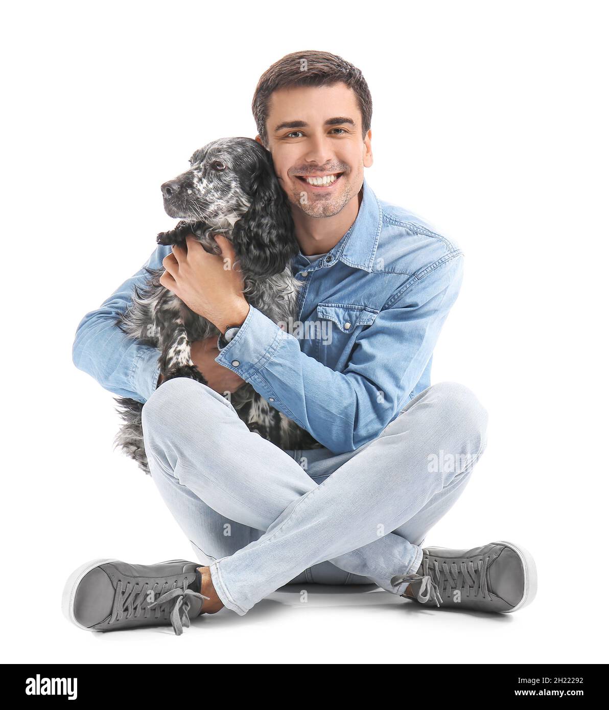 Happy young man with cute dog on white background Stock Photo - Alamy