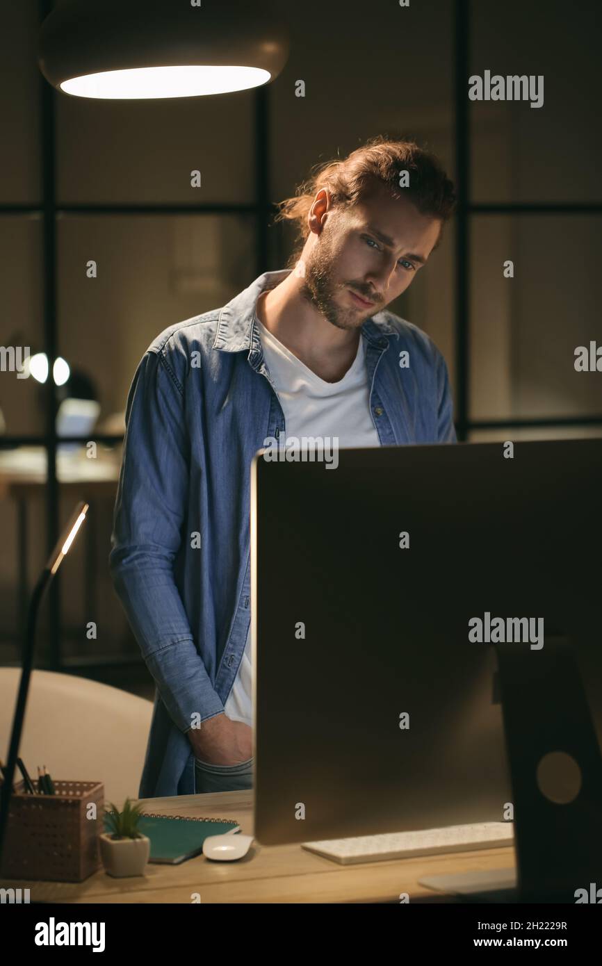 Young man working in office late in evening Stock Photo - Alamy