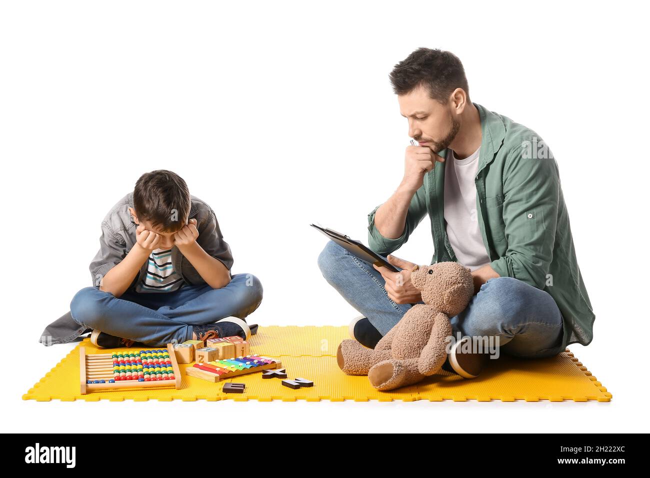 Male psychologist working with little boy on white background. Autism ...