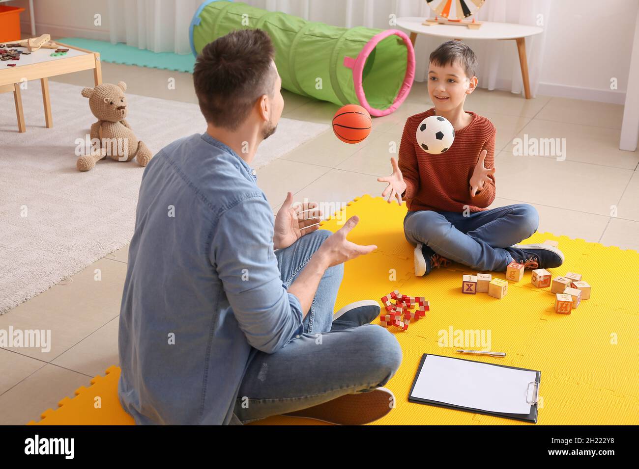 Male psychologist working with little boy in office. Autism concept ...