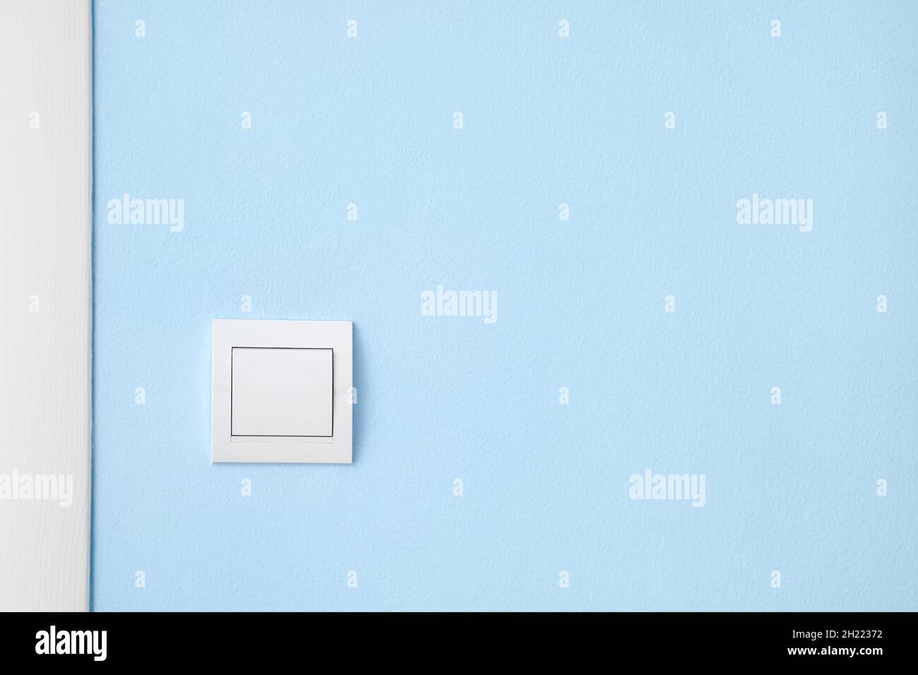 Modern switch on blue wall Stock Photo - Alamy