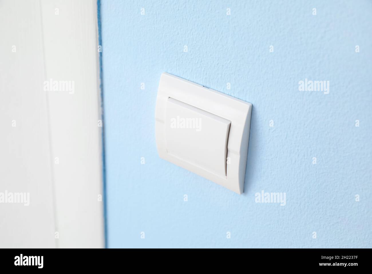 Modern switch on blue wall Stock Photo - Alamy
