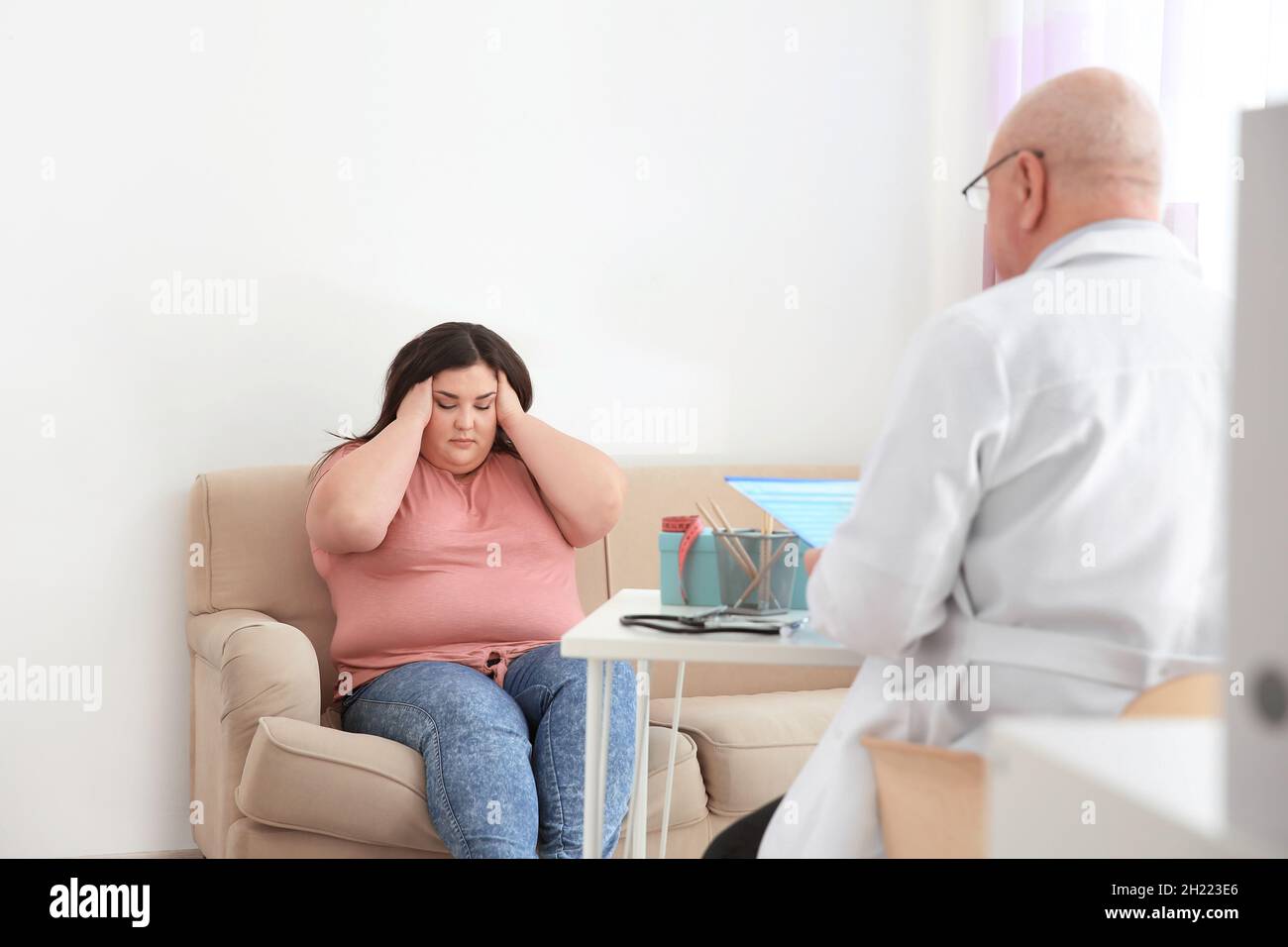 Emotional overweight woman having consultation at doctor's office Stock ...