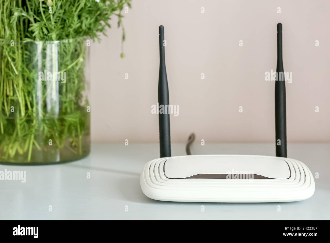Modern wi-fi router on table near light wall Stock Photo - Alamy