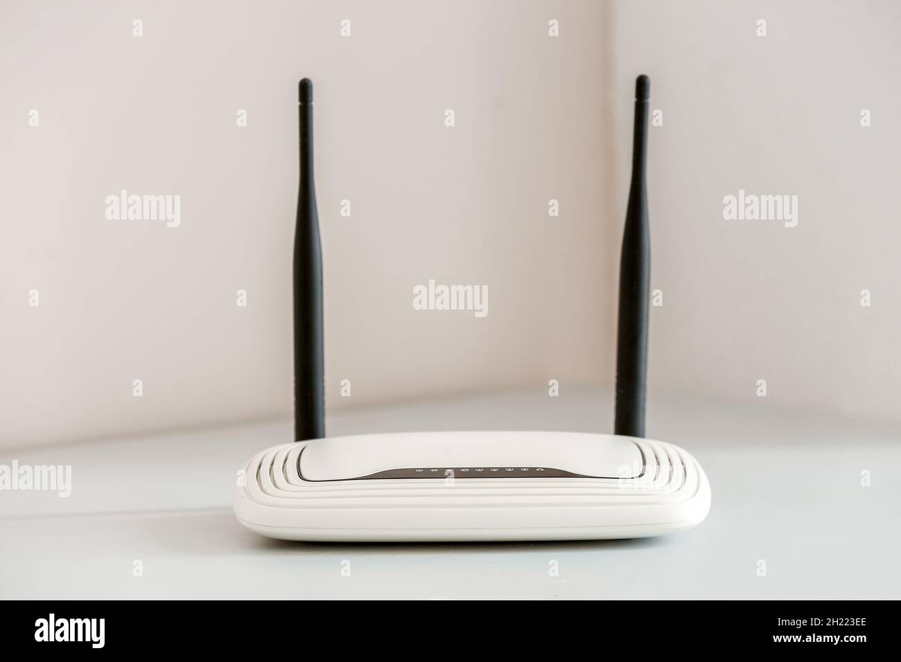 Modern wi-fi router on table near light wall Stock Photo - Alamy