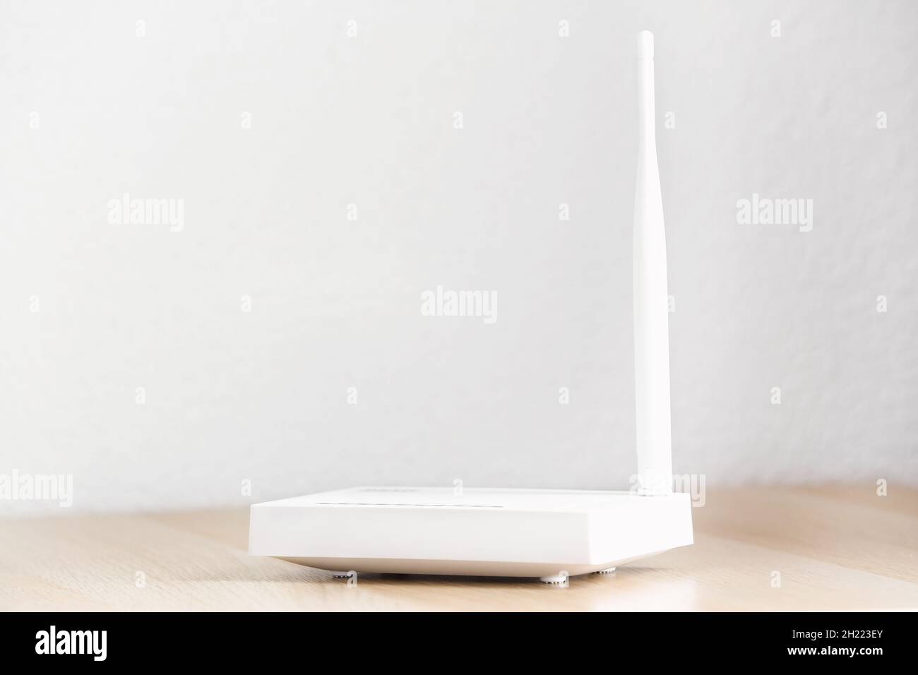 Modern wi-fi router on table near light wall Stock Photo - Alamy