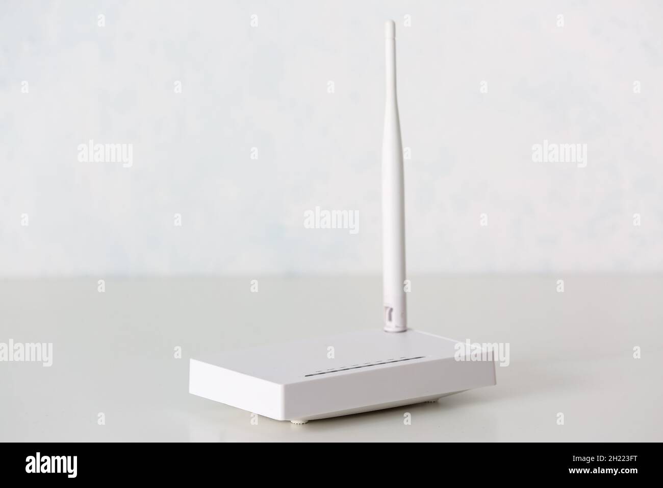 Modern wi-fi router on table near light wall Stock Photo - Alamy