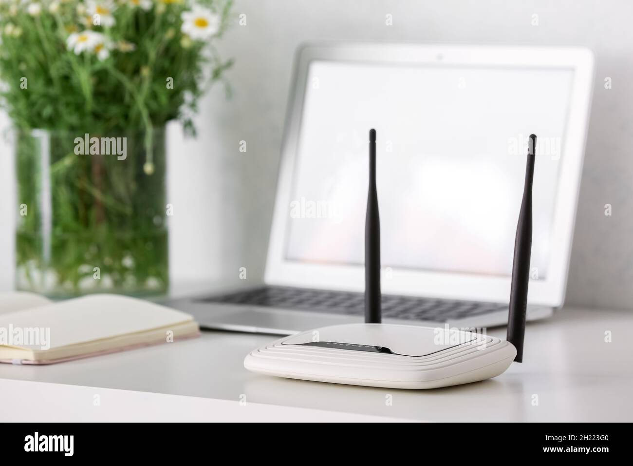 Modern wi-fi router on table near white wall Stock Photo - Alamy