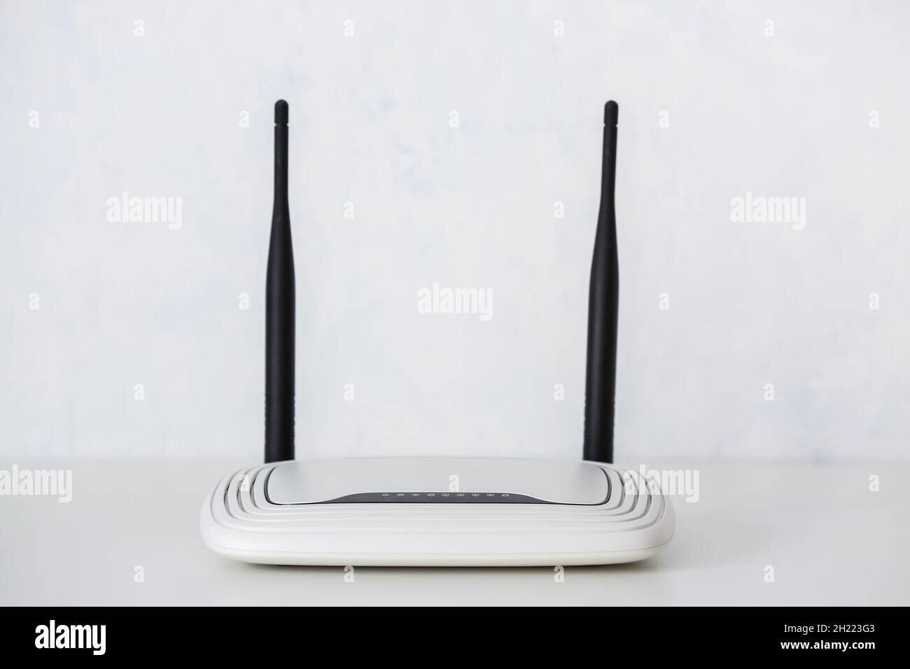 Modern wi-fi router on table near light wall Stock Photo - Alamy