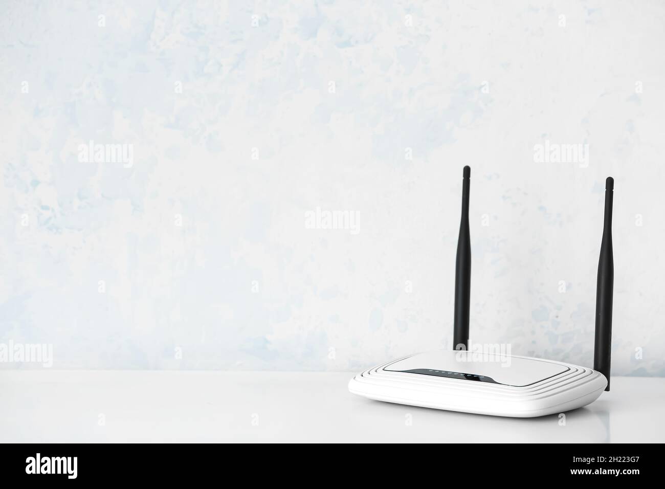Modern wi-fi router on table near white wall Stock Photo - Alamy
