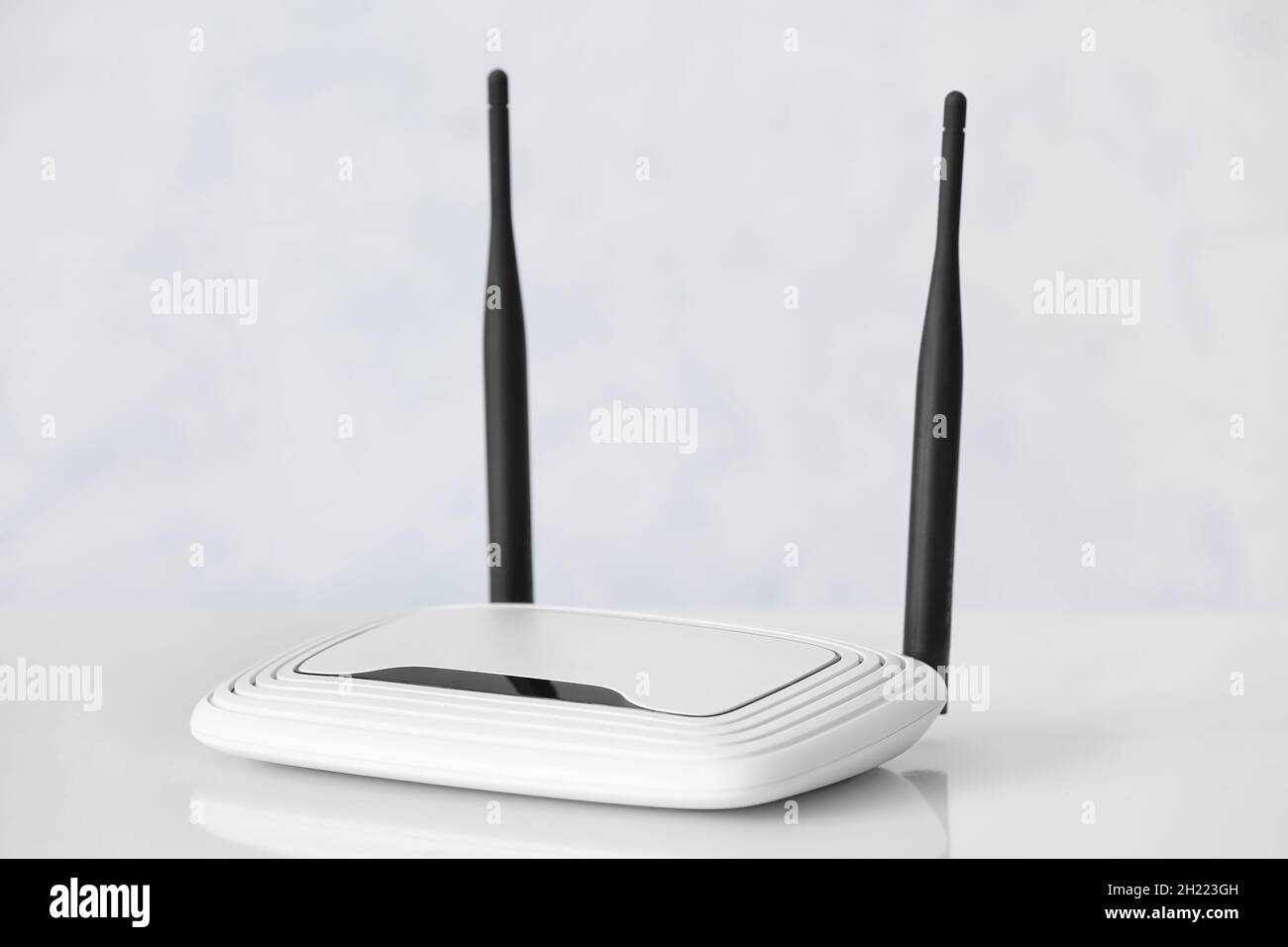 Modern wi-fi router on table near white wall Stock Photo - Alamy