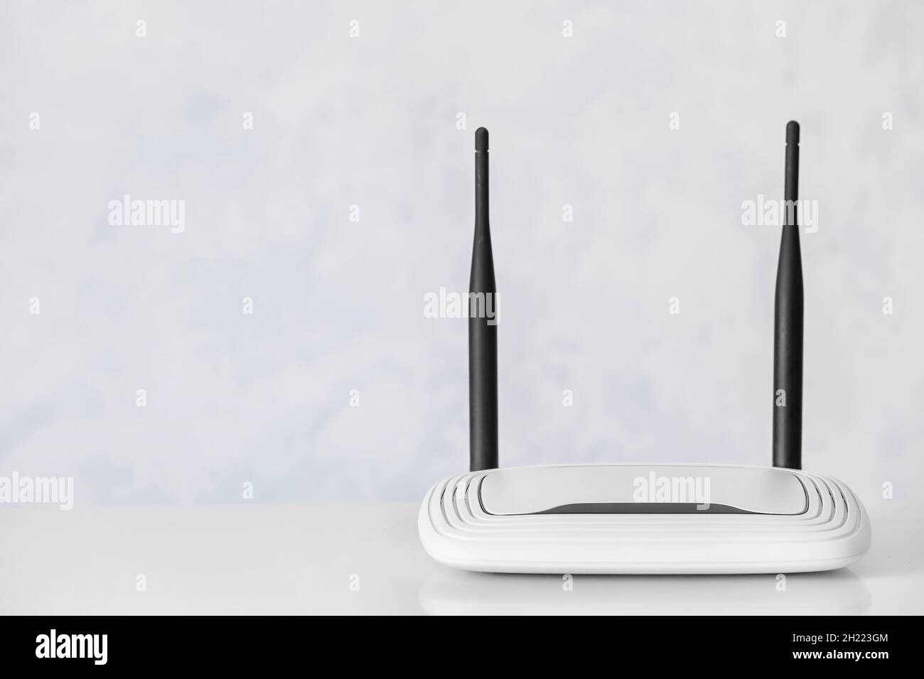 Modern wi-fi router on table near white wall Stock Photo - Alamy