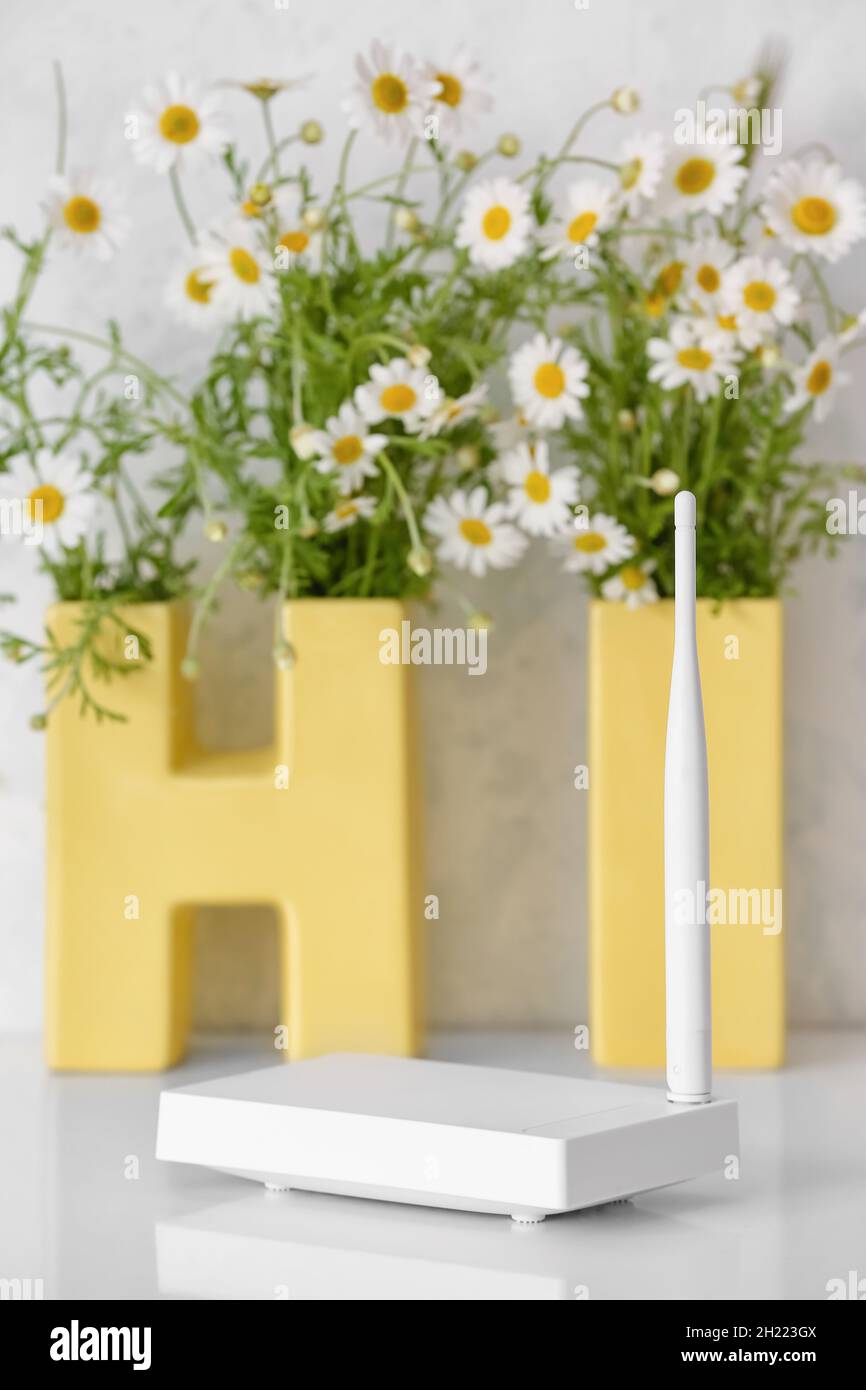 Modern wi-fi router on table near light wall Stock Photo - Alamy
