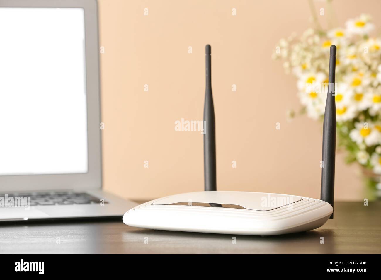 Modern wi-fi router on table near beige wall Stock Photo - Alamy