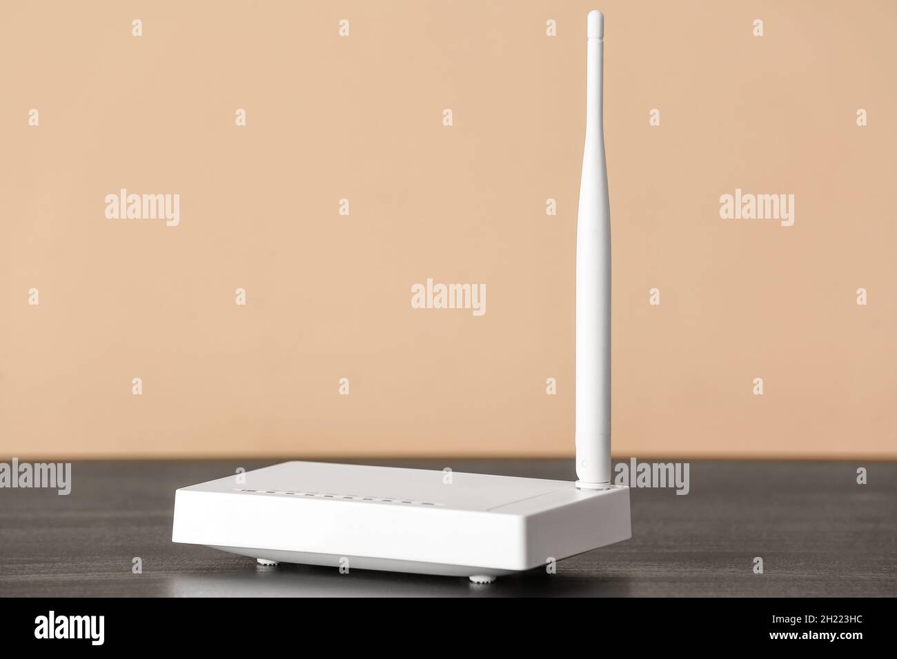 Modern wi-fi router on table near beige wall Stock Photo - Alamy