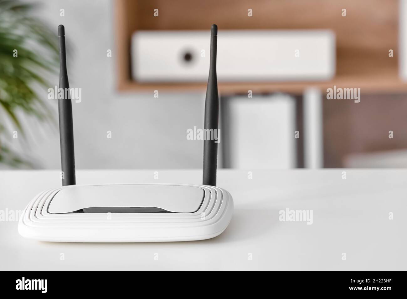 Modern wi-fi router on table in office Stock Photo - Alamy