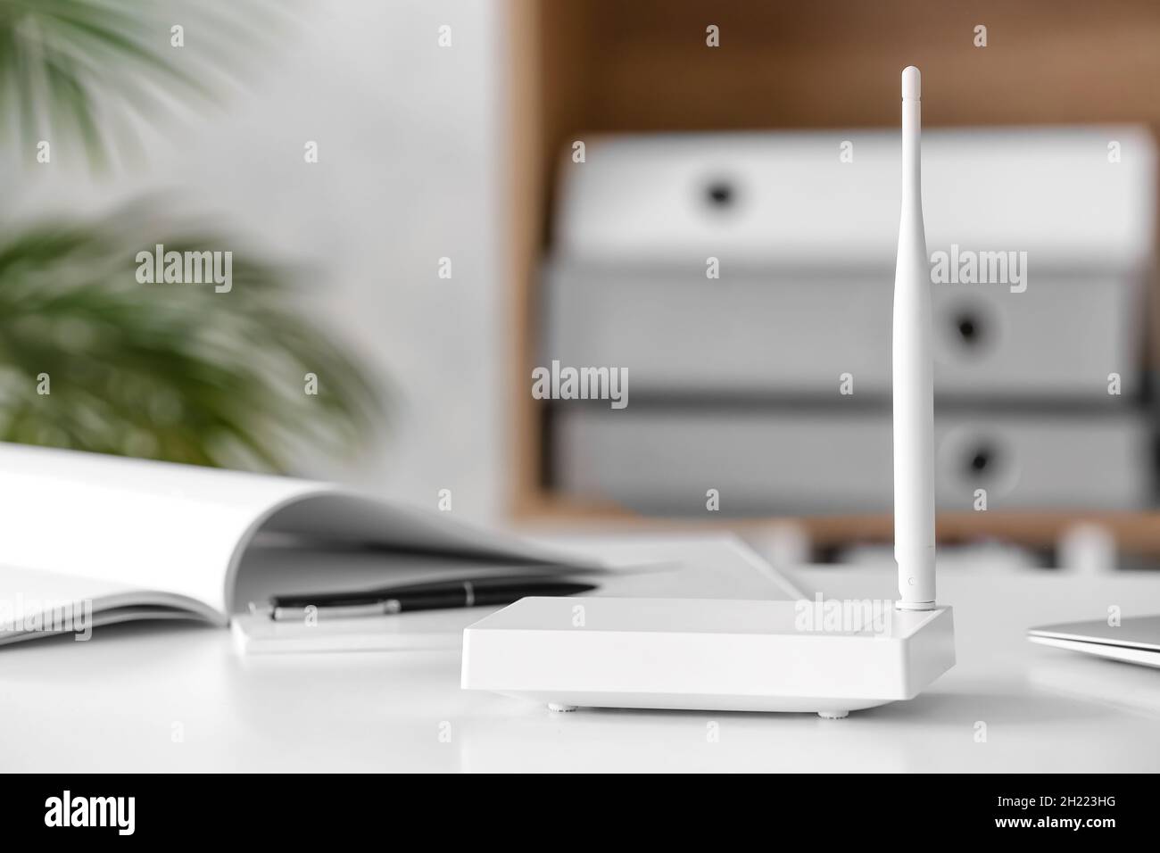 Modern wi-fi router on table in office Stock Photo - Alamy