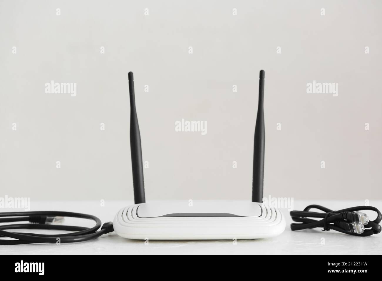 Modern wi-fi router on table near white wall Stock Photo - Alamy