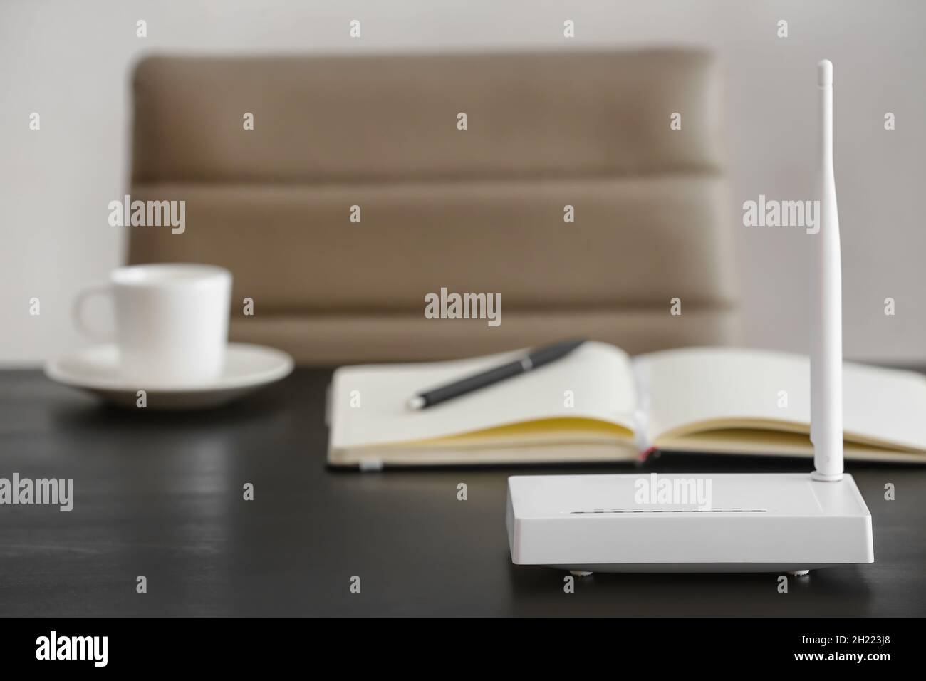 Modern wi-fi router on table in office Stock Photo - Alamy