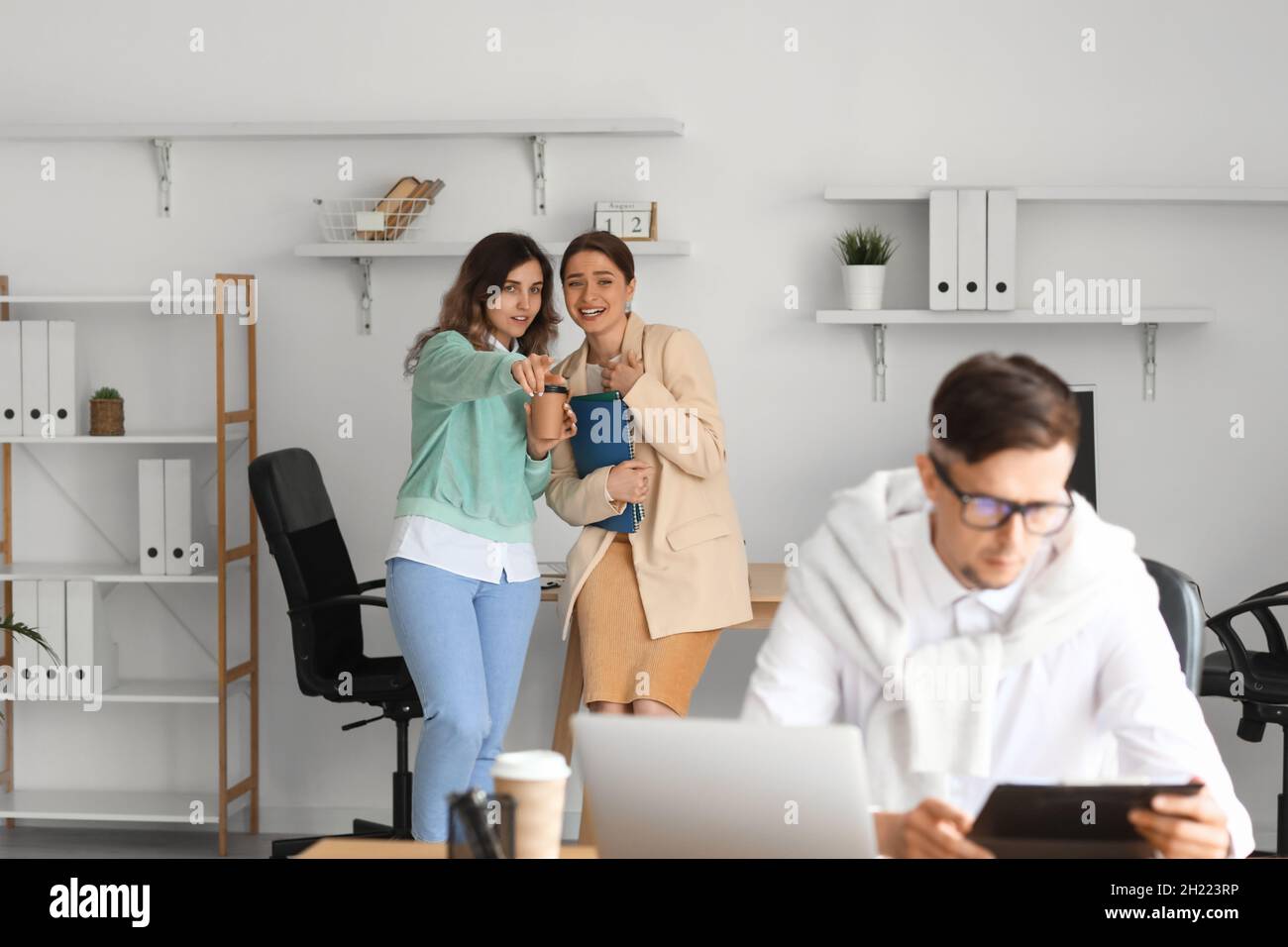 Women gossiping about their colleague in office Stock Photo - Alamy