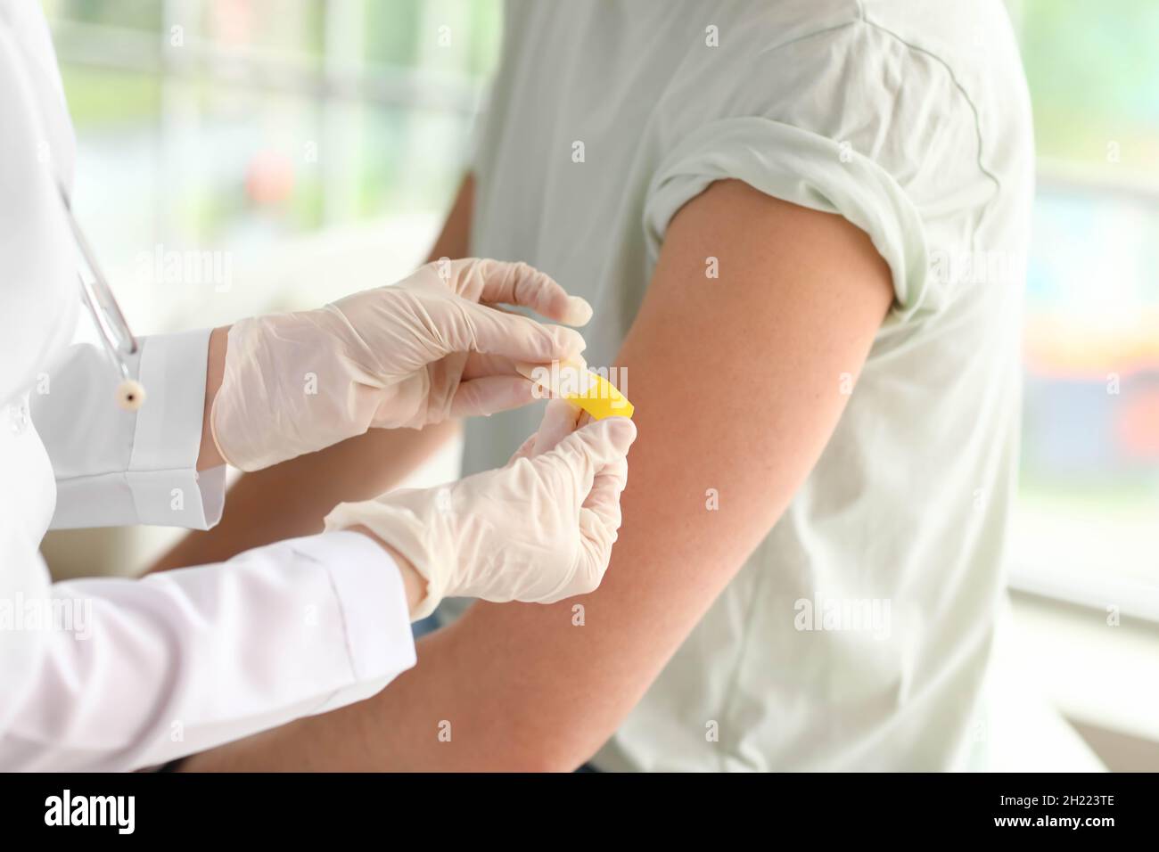 Doctor applying medical patch on patient's arm in clinic Stock Photo ...