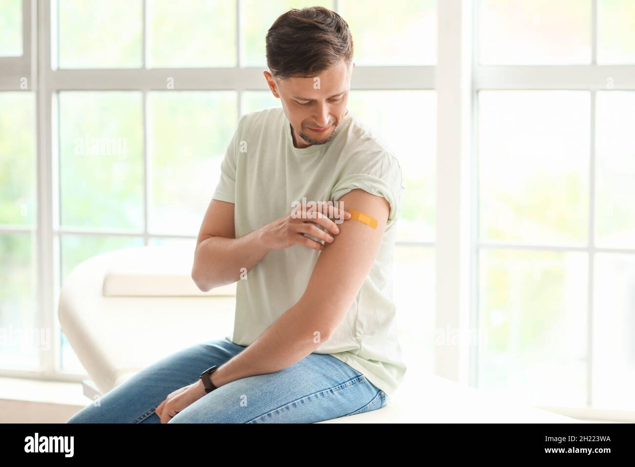 Man with medical patch on his arm in clinic Stock Photo - Alamy