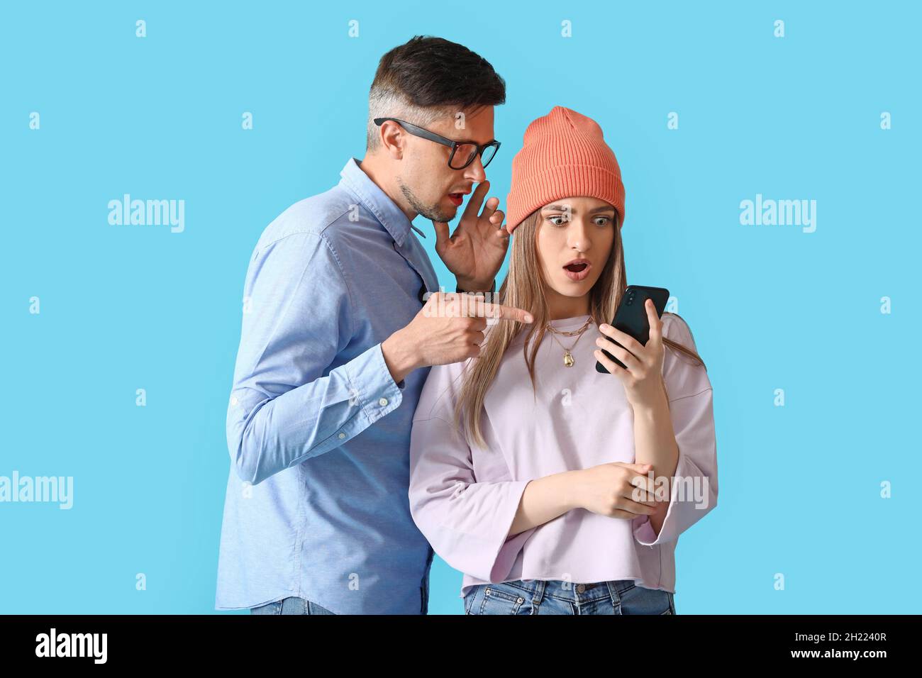 Gossiping people with phone on color background Stock Photo - Alamy