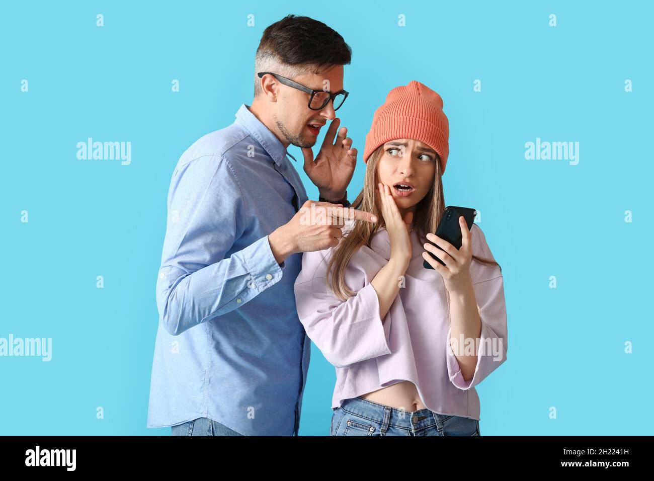 Gossiping people with phone on color background Stock Photo - Alamy