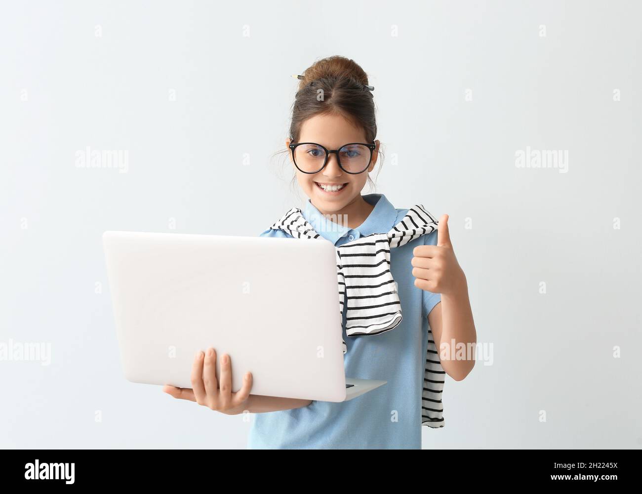 Little programmer with laptop showing thumb-up on light background ...