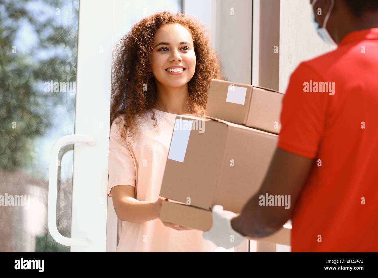 Customer receiving parcel from delivery man Stock Photo - Alamy