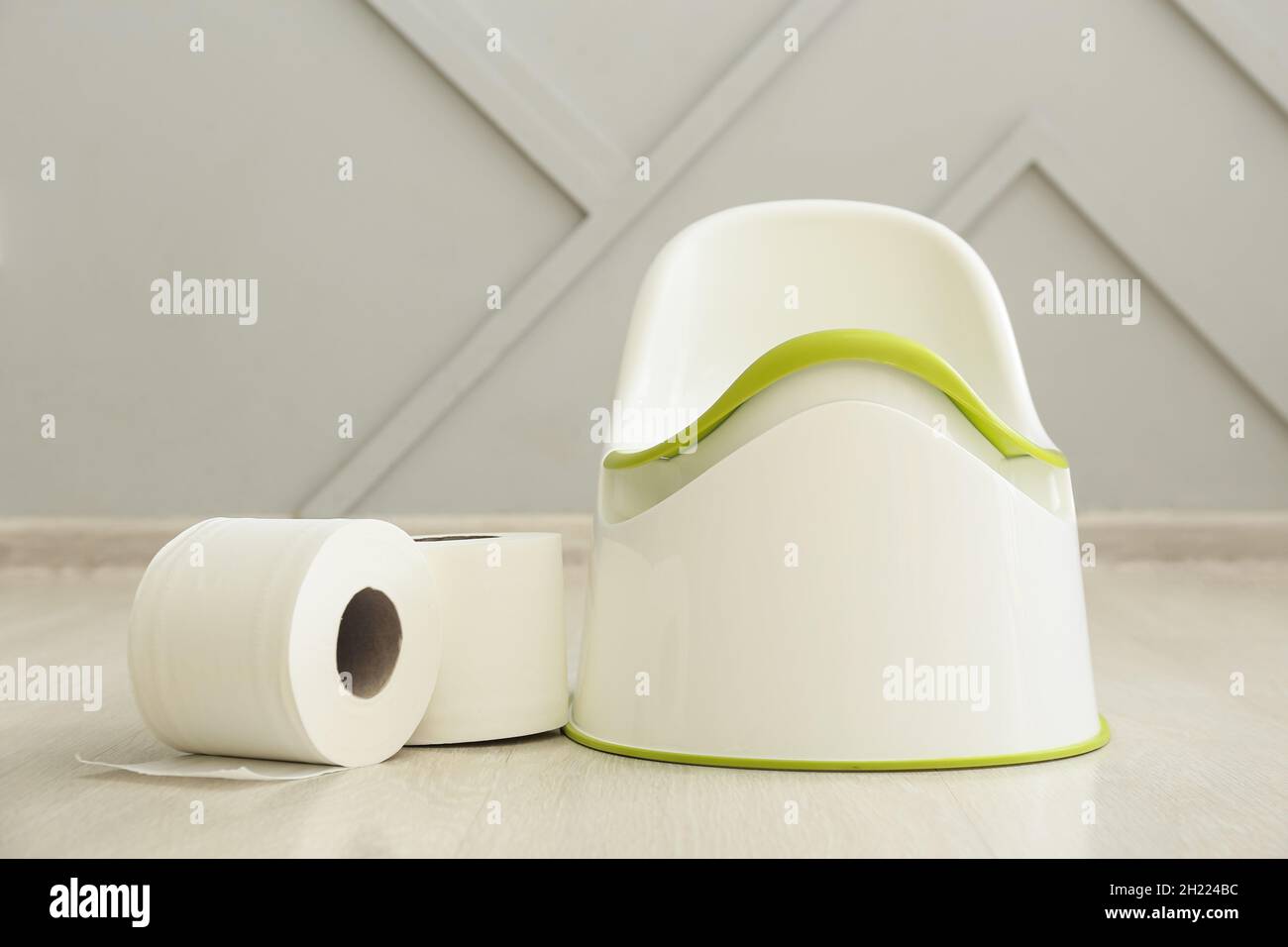 Potty and toilet paper rolls on floor near grey wall Stock Photo - Alamy