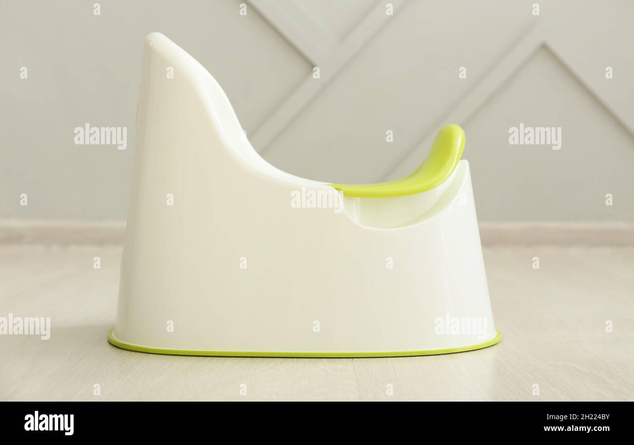 Modern potty on floor near grey wall Stock Photo - Alamy